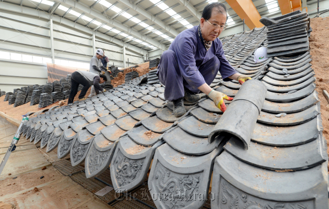Sungnyemun gets new roof tiles as restoration proceeds - The Korea Herald